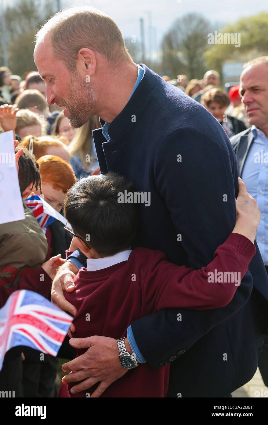 The Prince of Wales hugs a young well-wisher during a visit to a ...