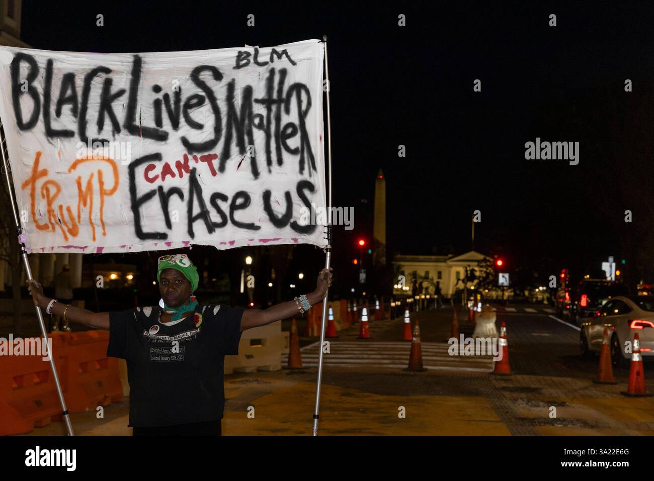 A demonstrator holds a sign after local government crews begin work to ...