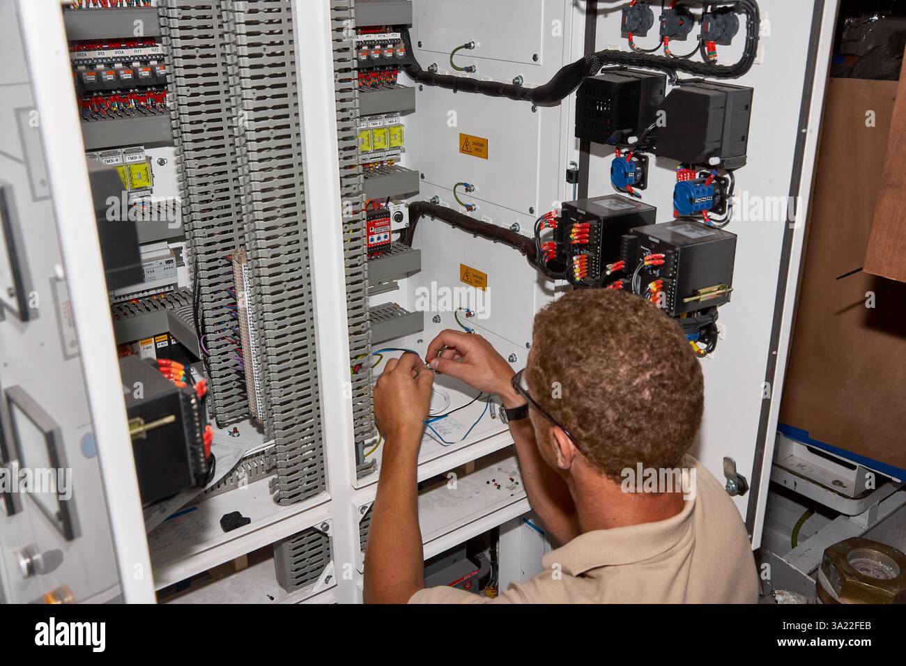 Technician Working Inside an Electrical Control Panel for Maintenance ...