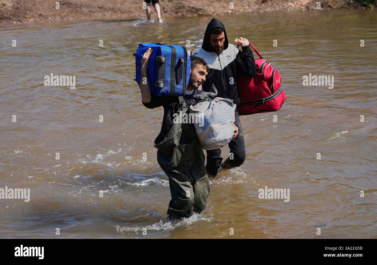 Syrian men who fled the clashes in Syria hold their luggages as they ...