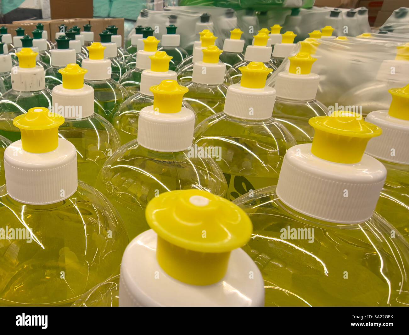 Rows of transparent bottles filled with vibrant yellow liquid create a ...
