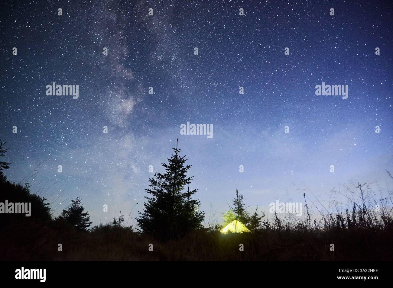 Radiant yellow tent beneath awe-inspiring, star-filled sky with Milky ...