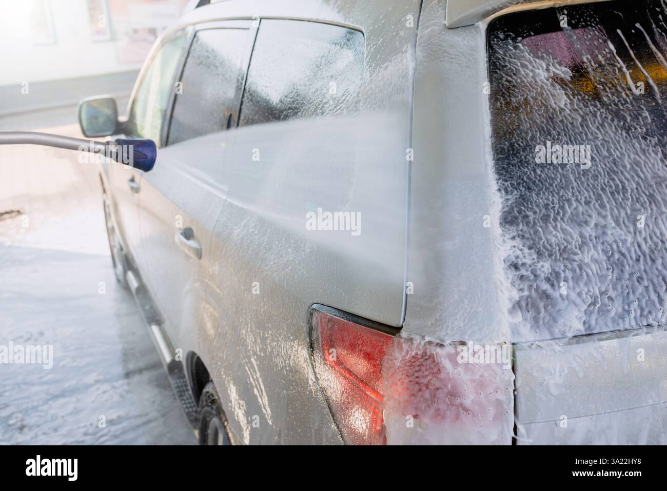 Washing an SUV with high-pressure water and foam at a self-service car ...