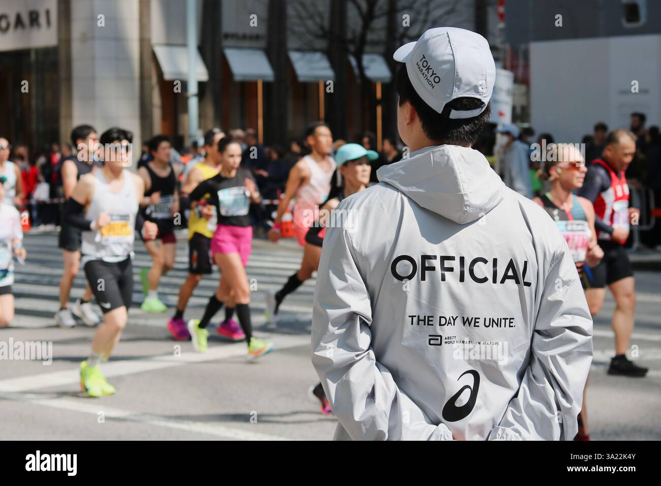 TOKYO, JAPAN - March 2, 2025: An official watching runners going ...