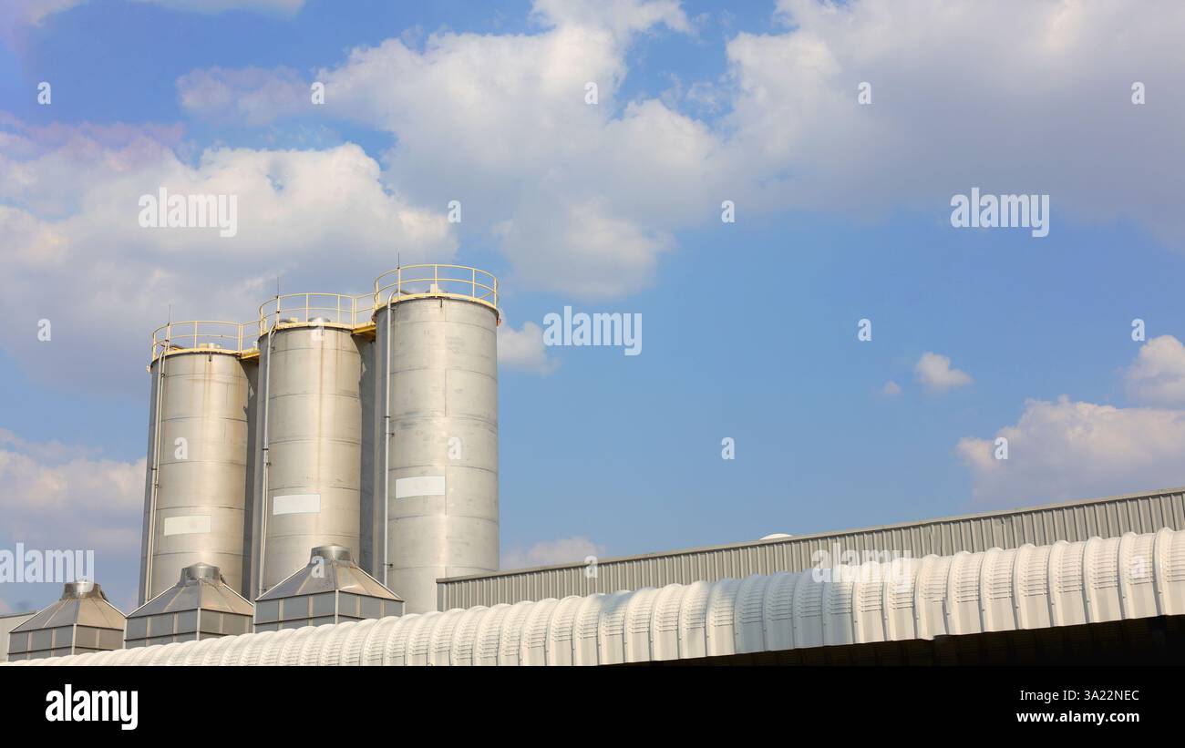 Stainless steel silo amidst blue sky. Warehouse for storing goods and ...