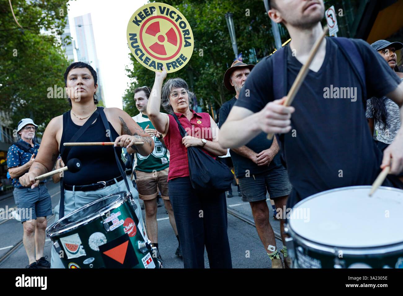 A protester holds a placard as others drum during the rally. March 11 ...