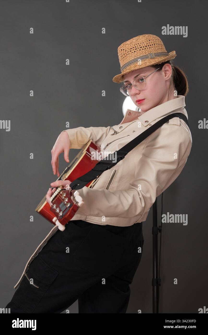 Side view of female guitarist plucking six string acoustic guitar and ...