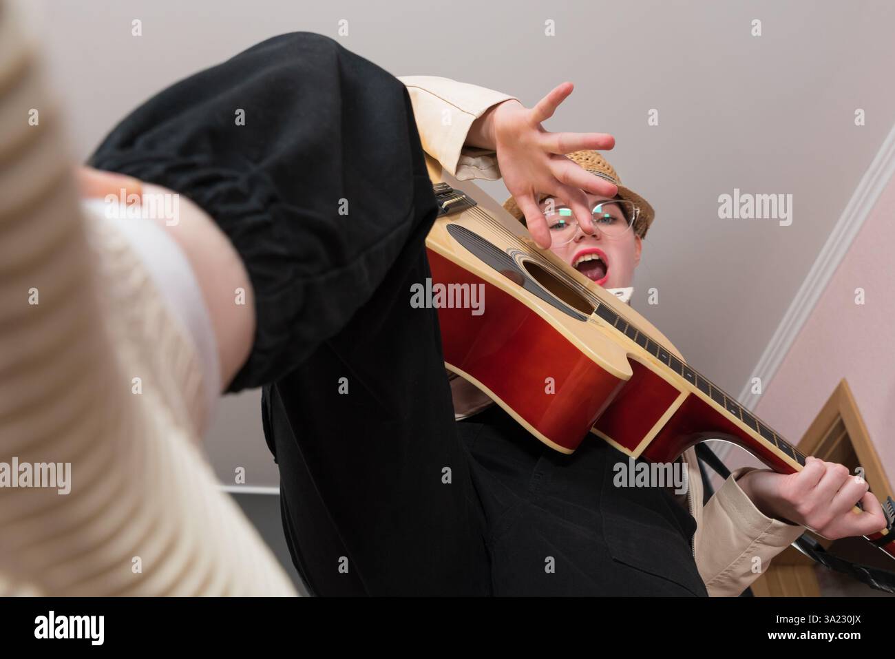 Low angle view of female guitarist and singer songwriter strumming ...