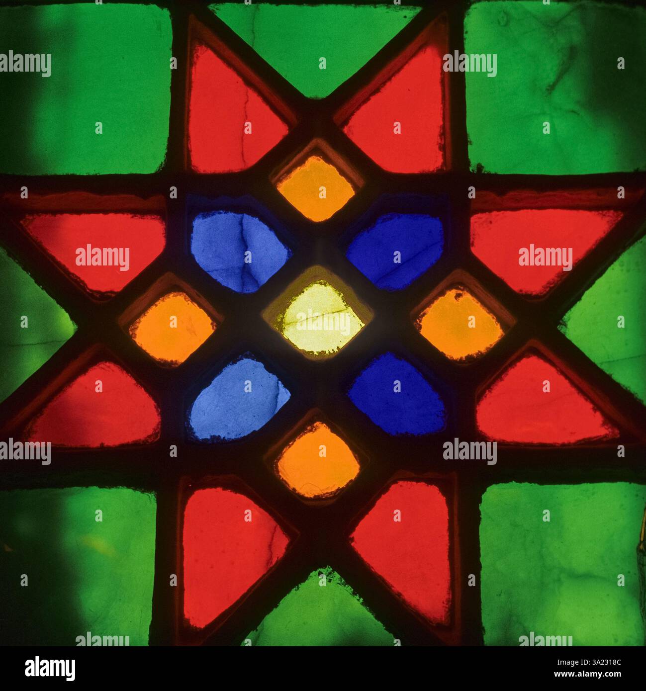 An eight-pointed stained glass star in red, green, blue, orange and ...