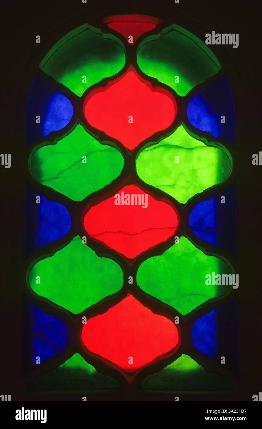 Curving stained glass shapes in red, blue and green within the takhrim ...