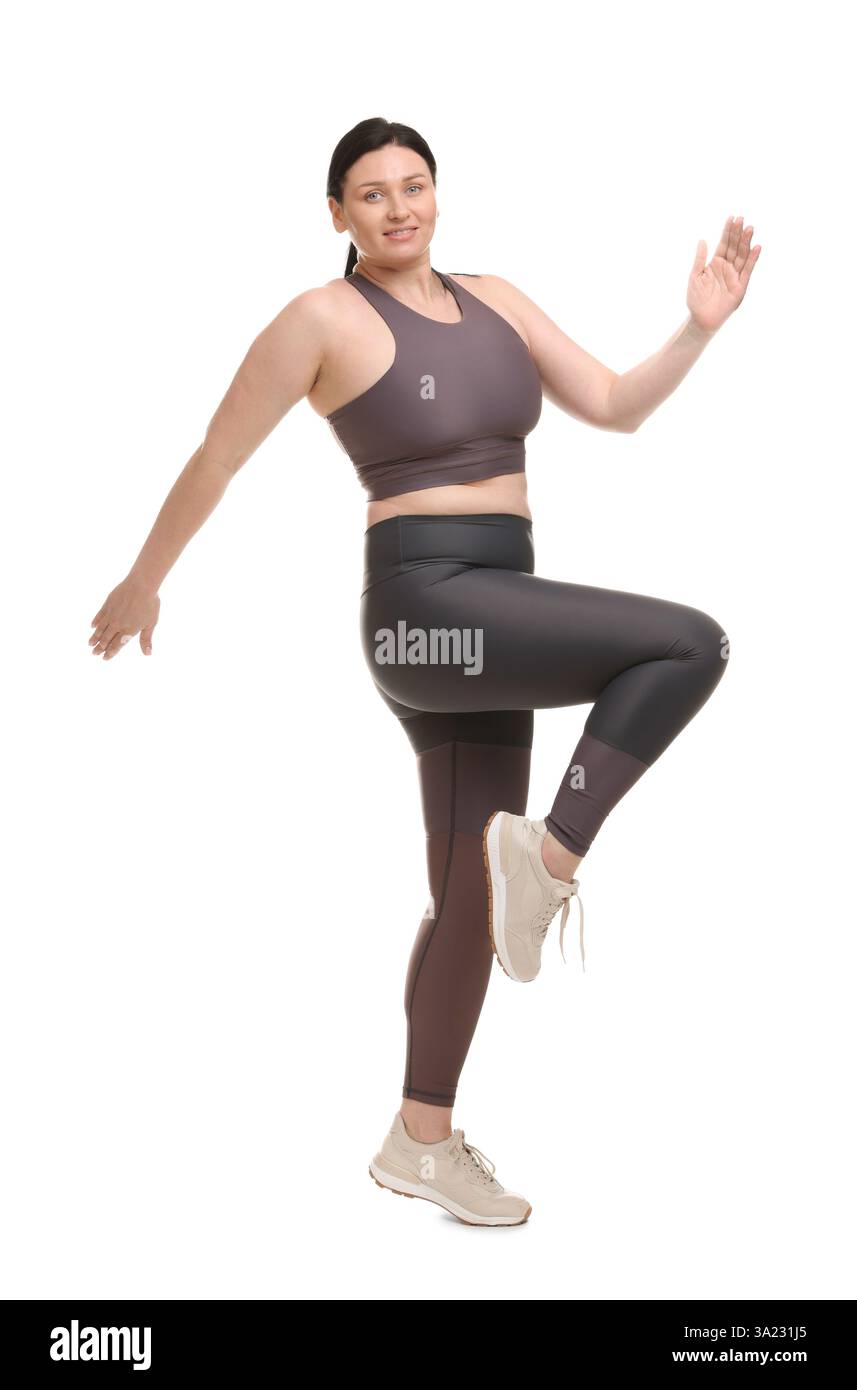 Plus size woman in gym clothes exercising on white background Stock ...