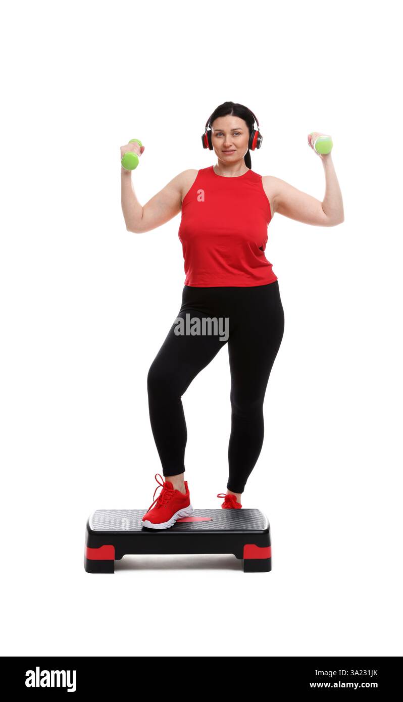 Plus size woman in gym clothes doing exercise with step platform and ...