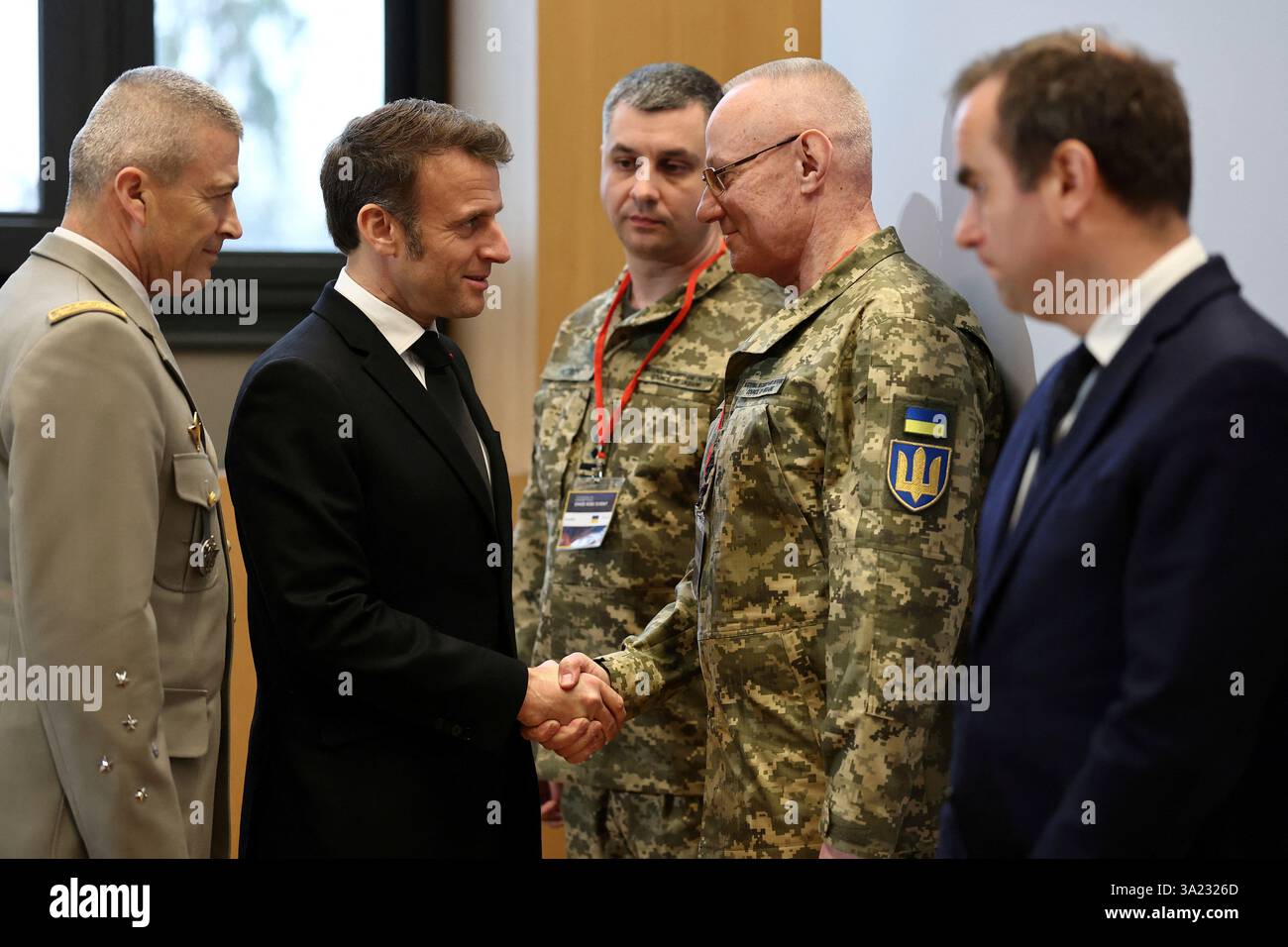 French President Emmanuel Macron, second left, , shakes hands with ...