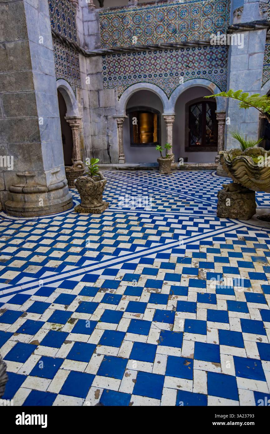 Vibrant blue and white tiles create a stunning pattern around a lush ...