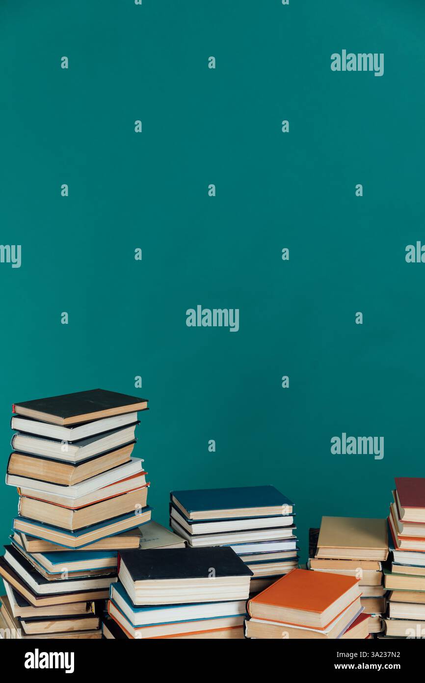 Stacks of old books on green library background Stock Photo - Alamy