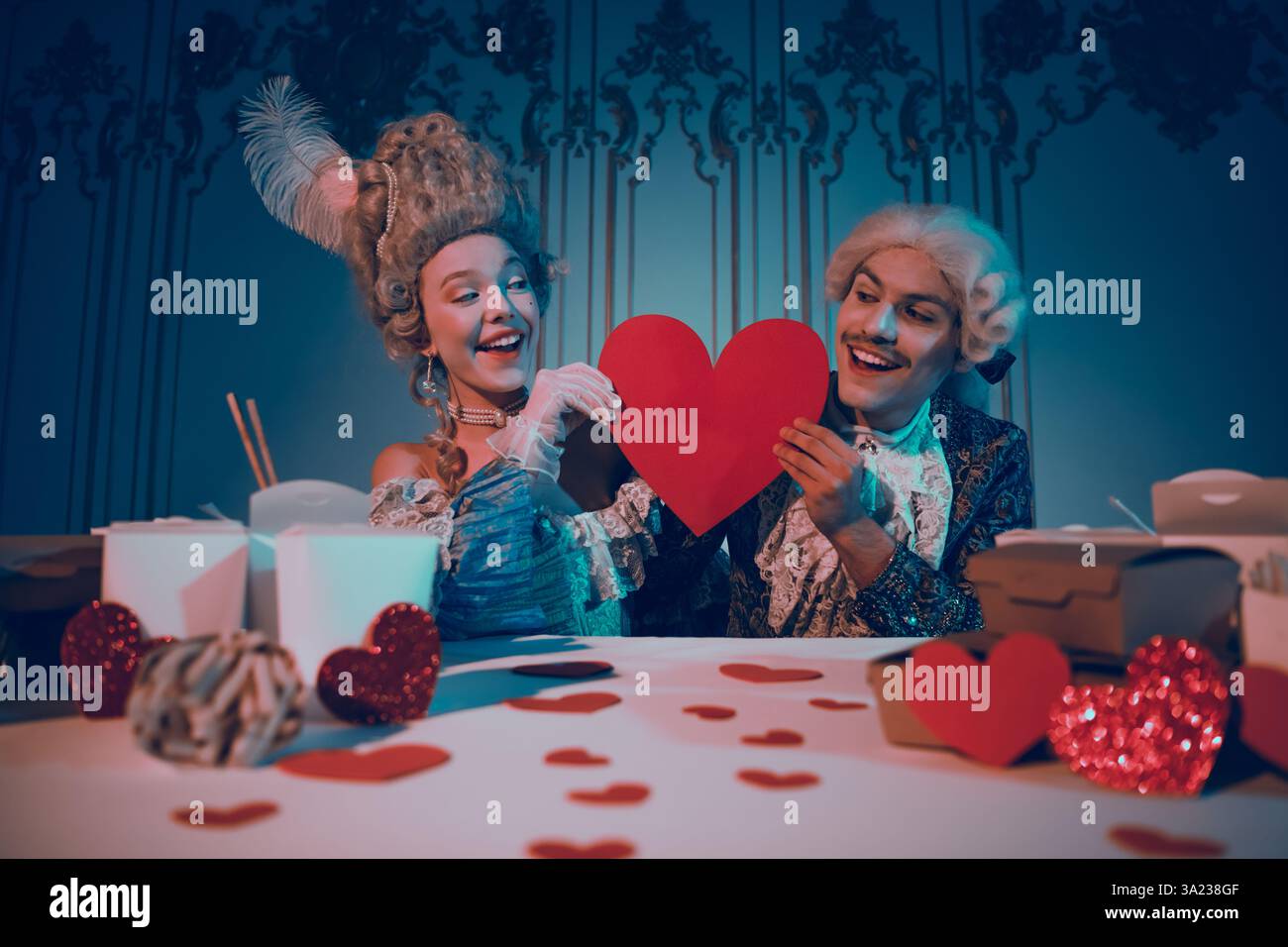 Elegant couple in baroque attire holding red heart in aristocratic ...