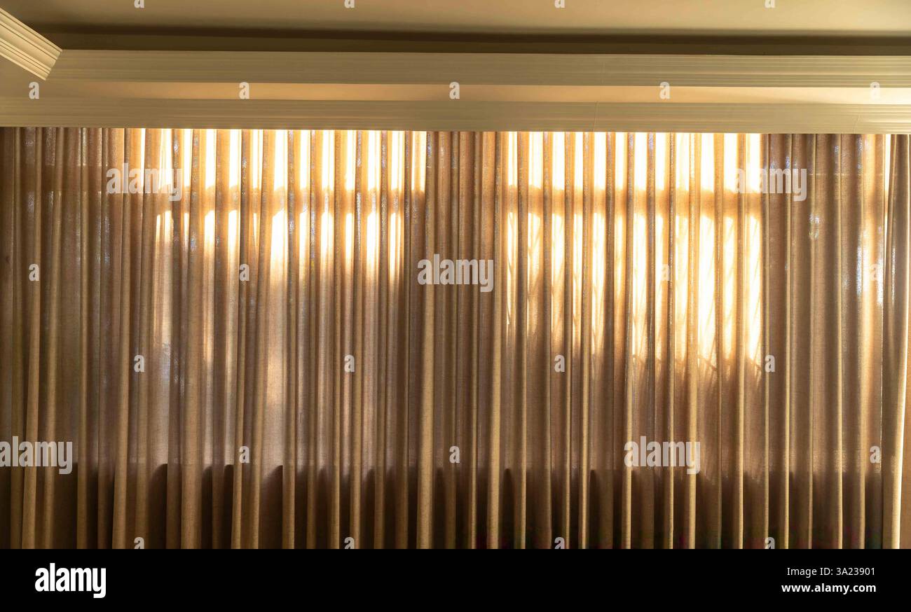 BEIGE CURTAIN IN BACKLIGHT IN THE ILLUMINATED WINDOW Stock Photo - Alamy