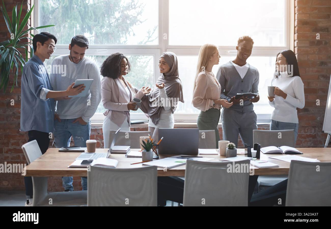 Friendly business team talking while having break Stock Photo - Alamy