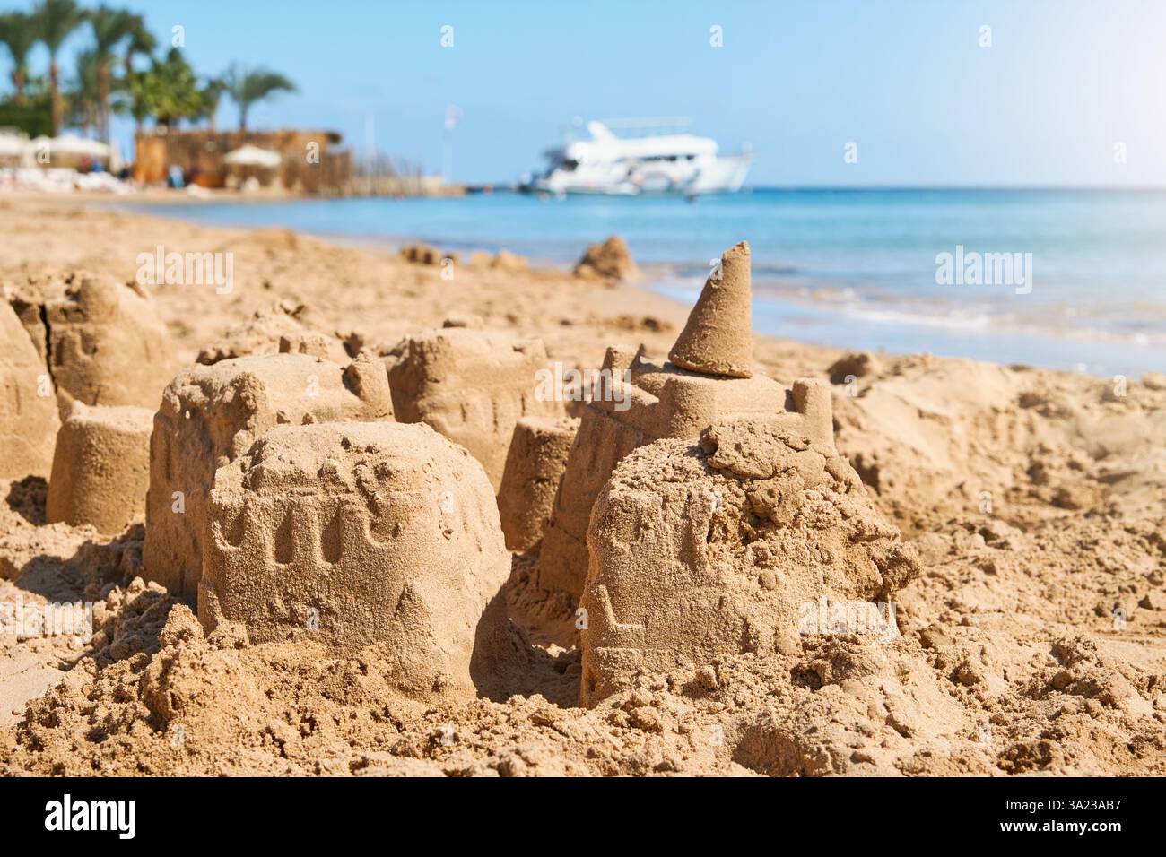 Simple sandcastle on fine sandy beach under the expansive blue sky ...