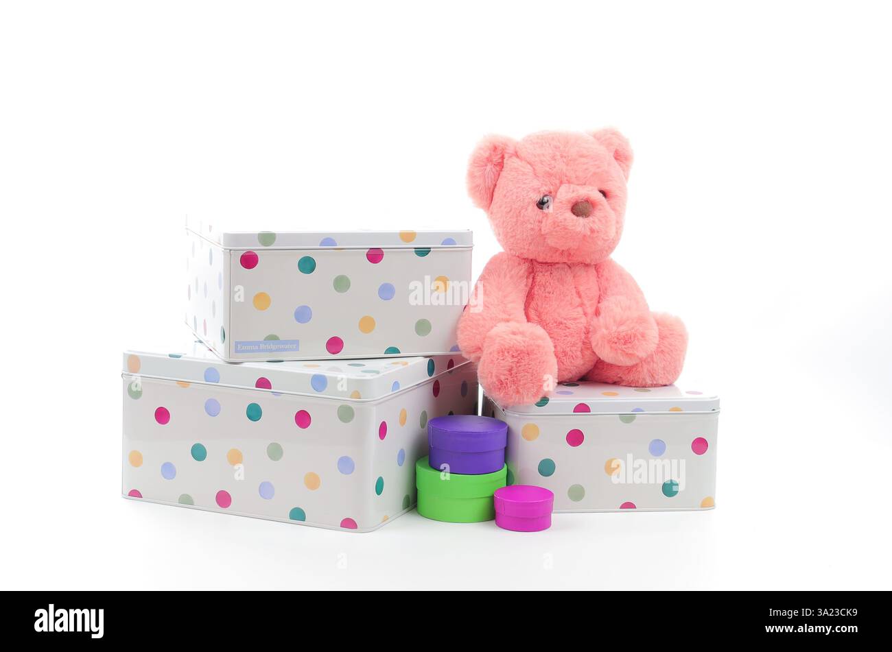 Cute pink coral Teddy Bear with a set of multicoloured boxes on a pure ...