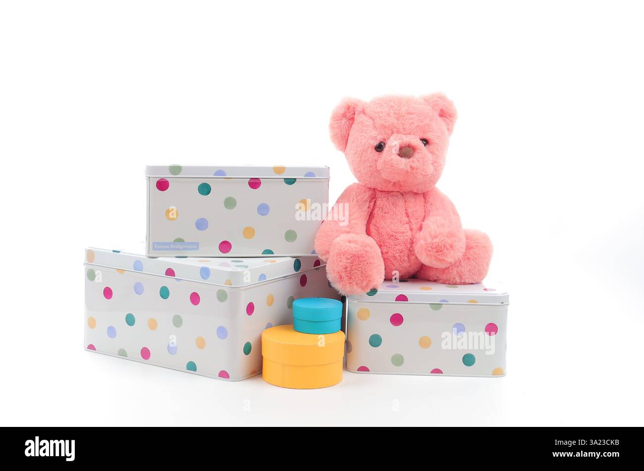 Cute pink coral Teddy Bear with a set of multicoloured boxes on a pure ...