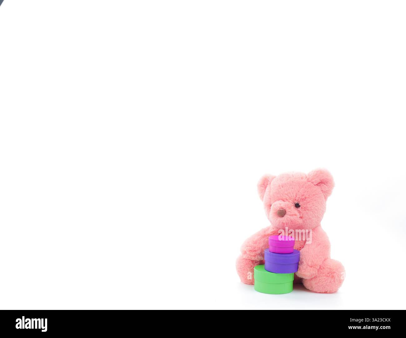 Cute pink coral Teddy Bear with a set of multicoloured boxes on a pure ...