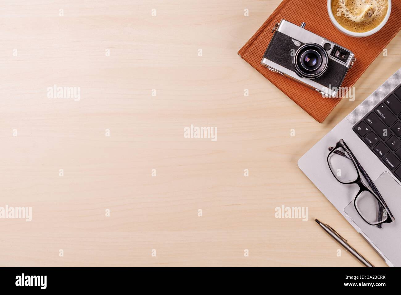A clean and minimal desk setup featuring a laptop and a coffee cup ...