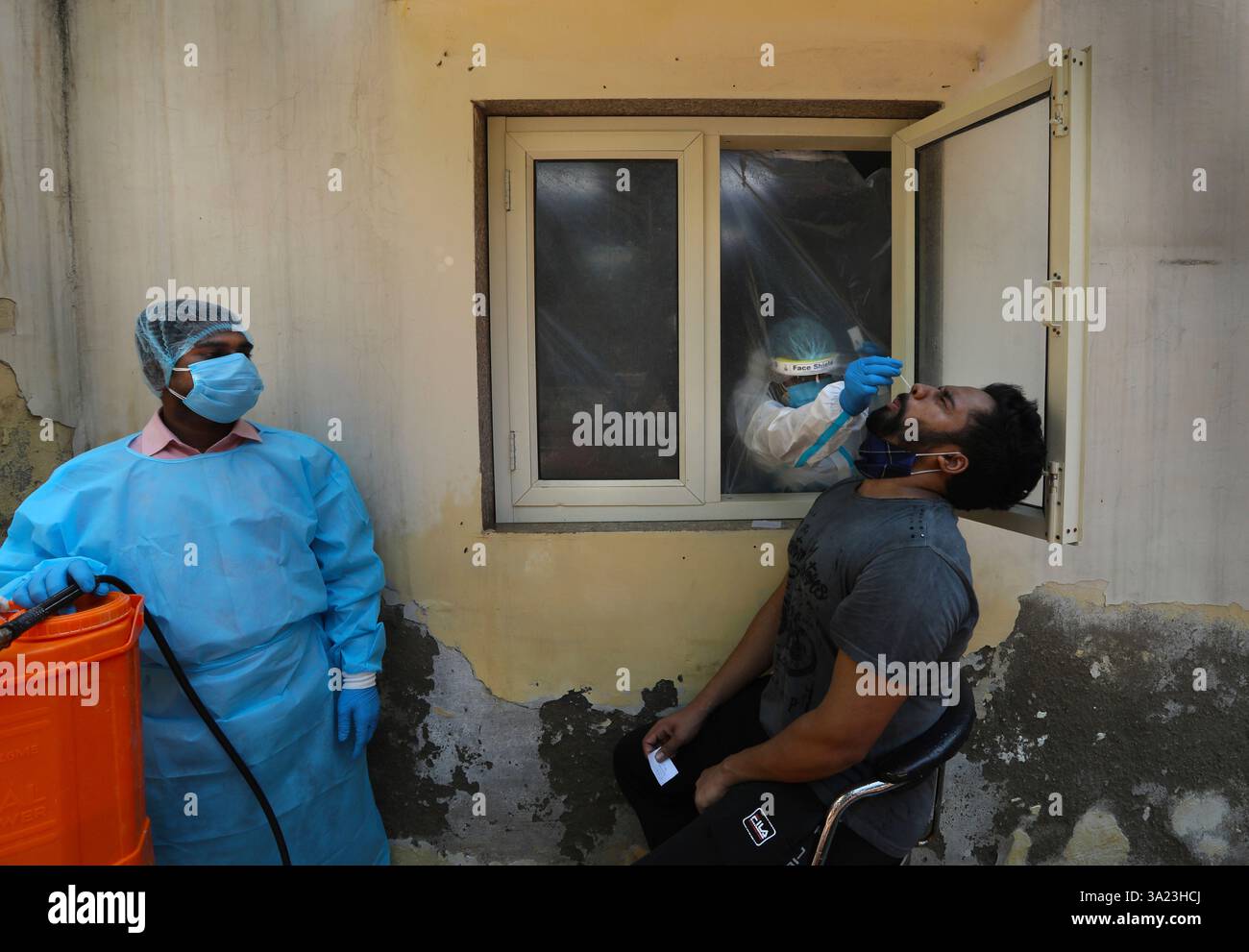 A health worker takes a nasal swab sample to test for COVID-19, as ...