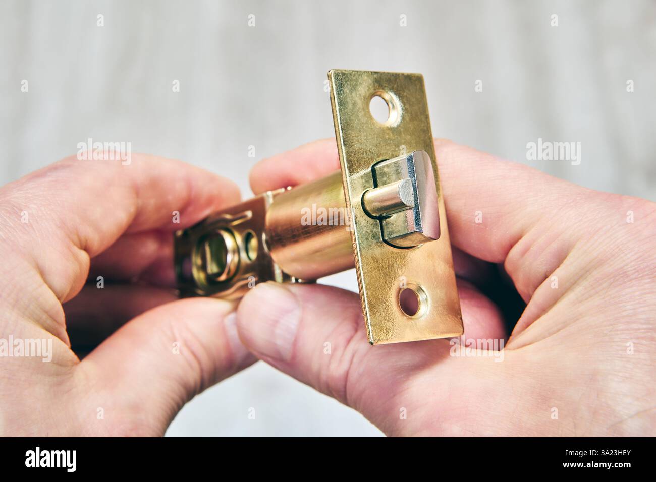 Tubular door latch with rectangular strike plate in human hands, close ...