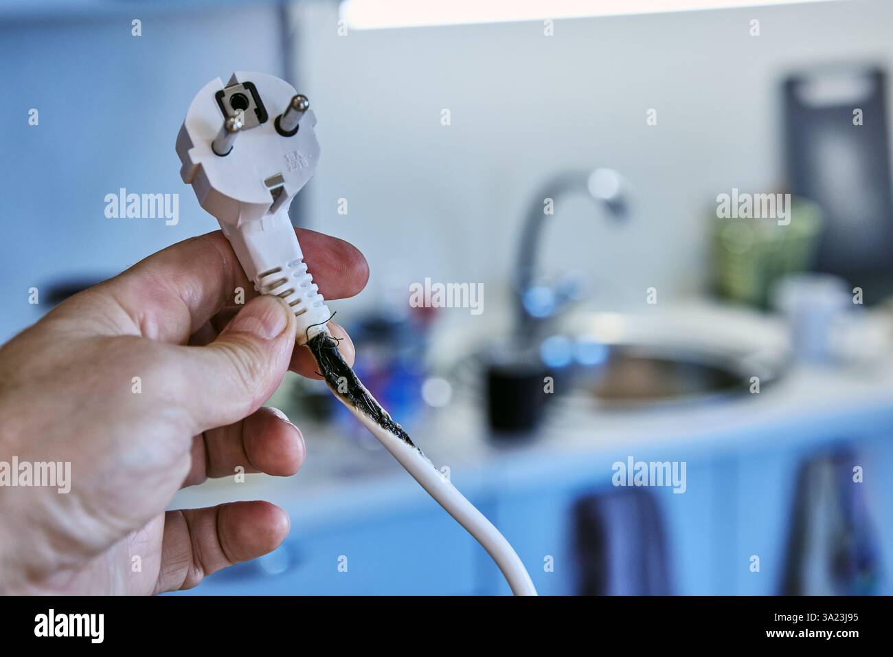 Burnt out cable with an electrical plug in hand of user who has ...