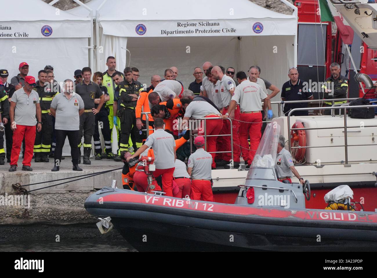A body bag is brought ashore at the harbour in Porticello by rescue ...