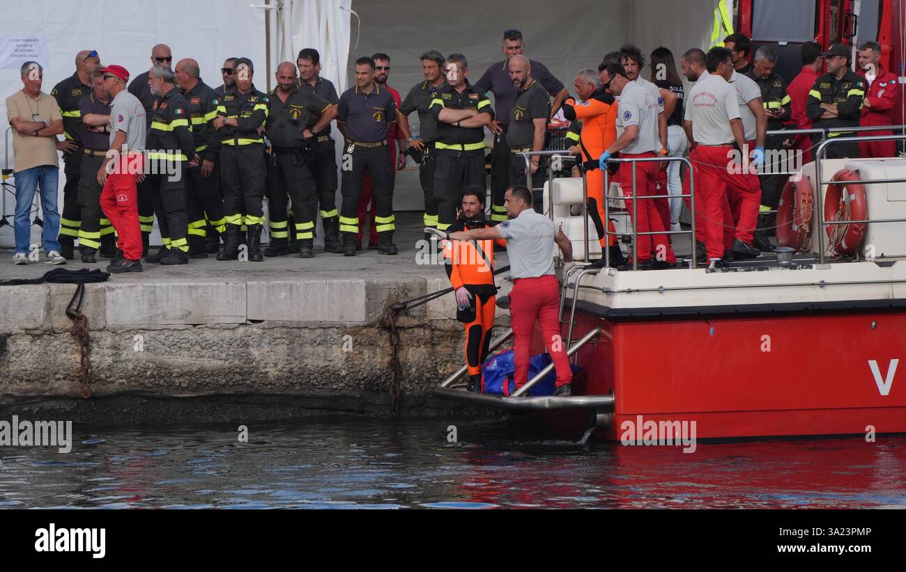 A body bag is brought ashore at the harbour in Porticello by rescue ...