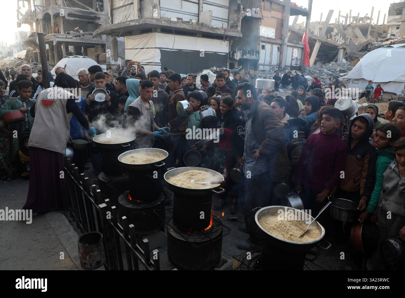 Jabalia, Gaza Strip. 11th Mar, 2025. People wait in front of a charity ...