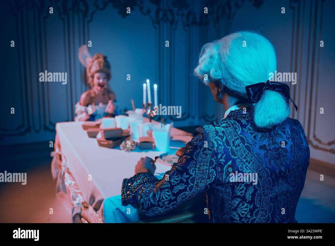 Couple in elegant baroque costumes enjoying a themed dinner in a ...