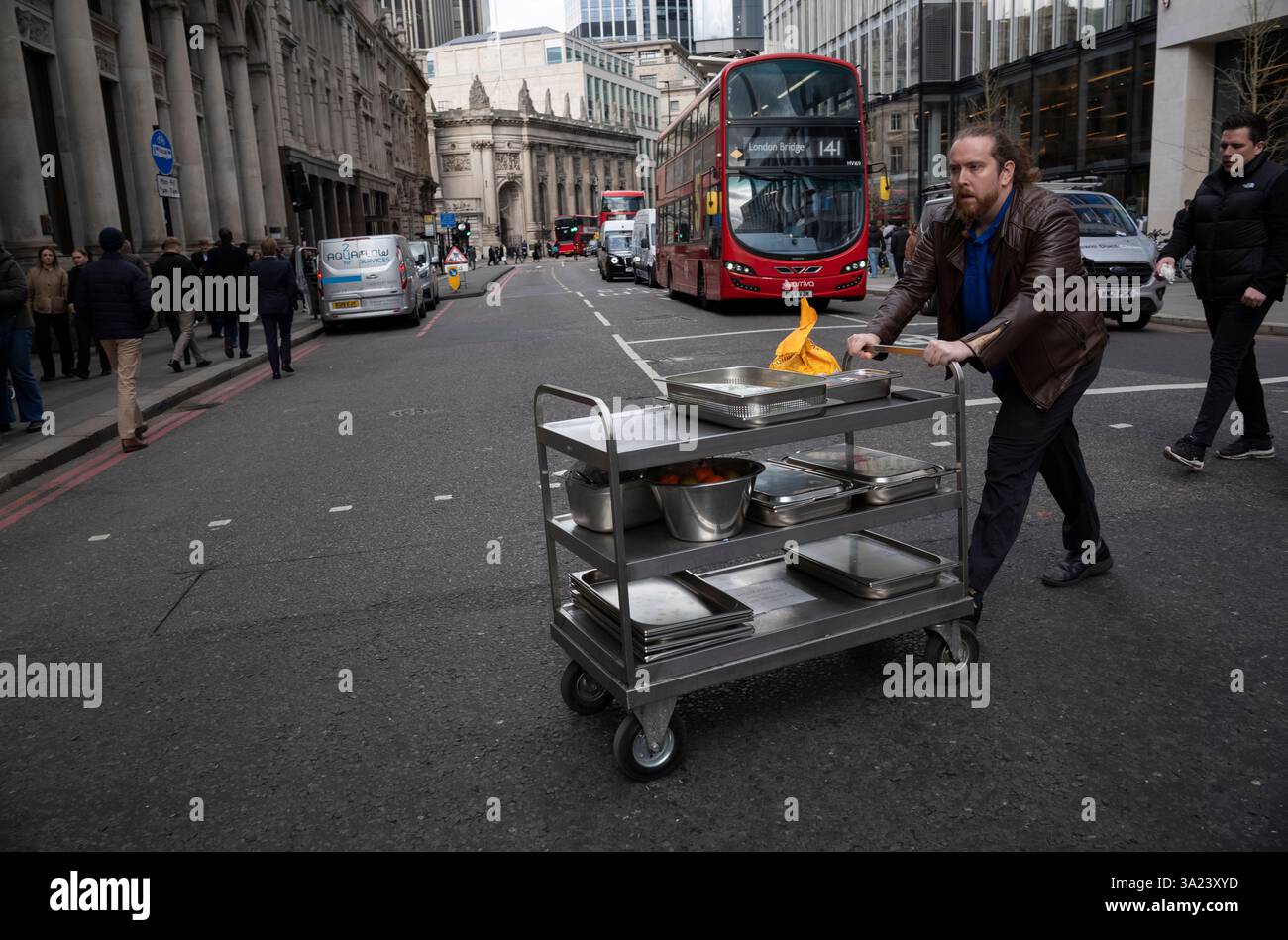 A city worker pushes a catering trolley across Bishopsgate pedestrian ...