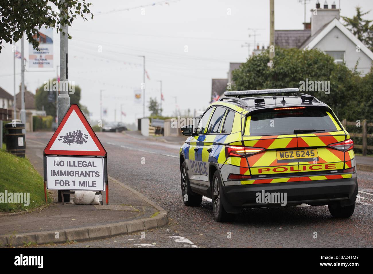 PSNI officers arrive to remove a road sign with image of people a dingy ...