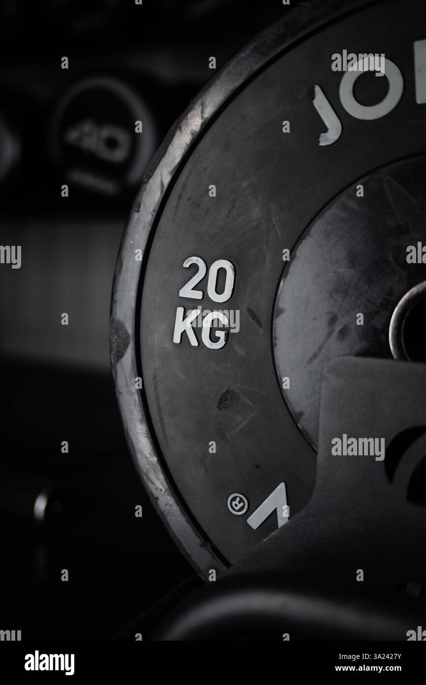 A close up of a weight plate that says 20 kg on it. Concept of strength ...