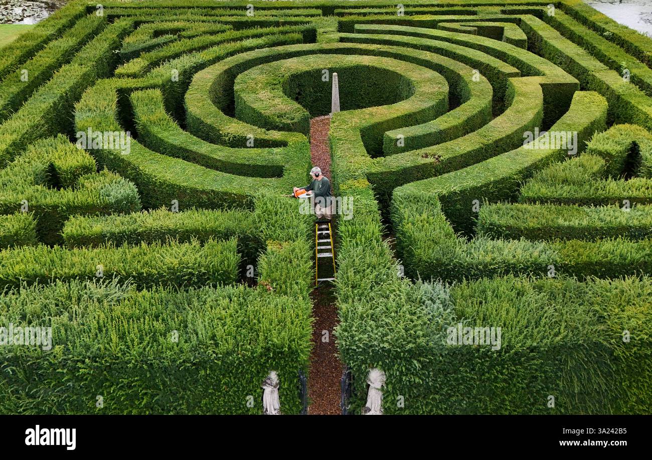 A gardener at Hever Castle tends to the bushes of the historic 120-year ...