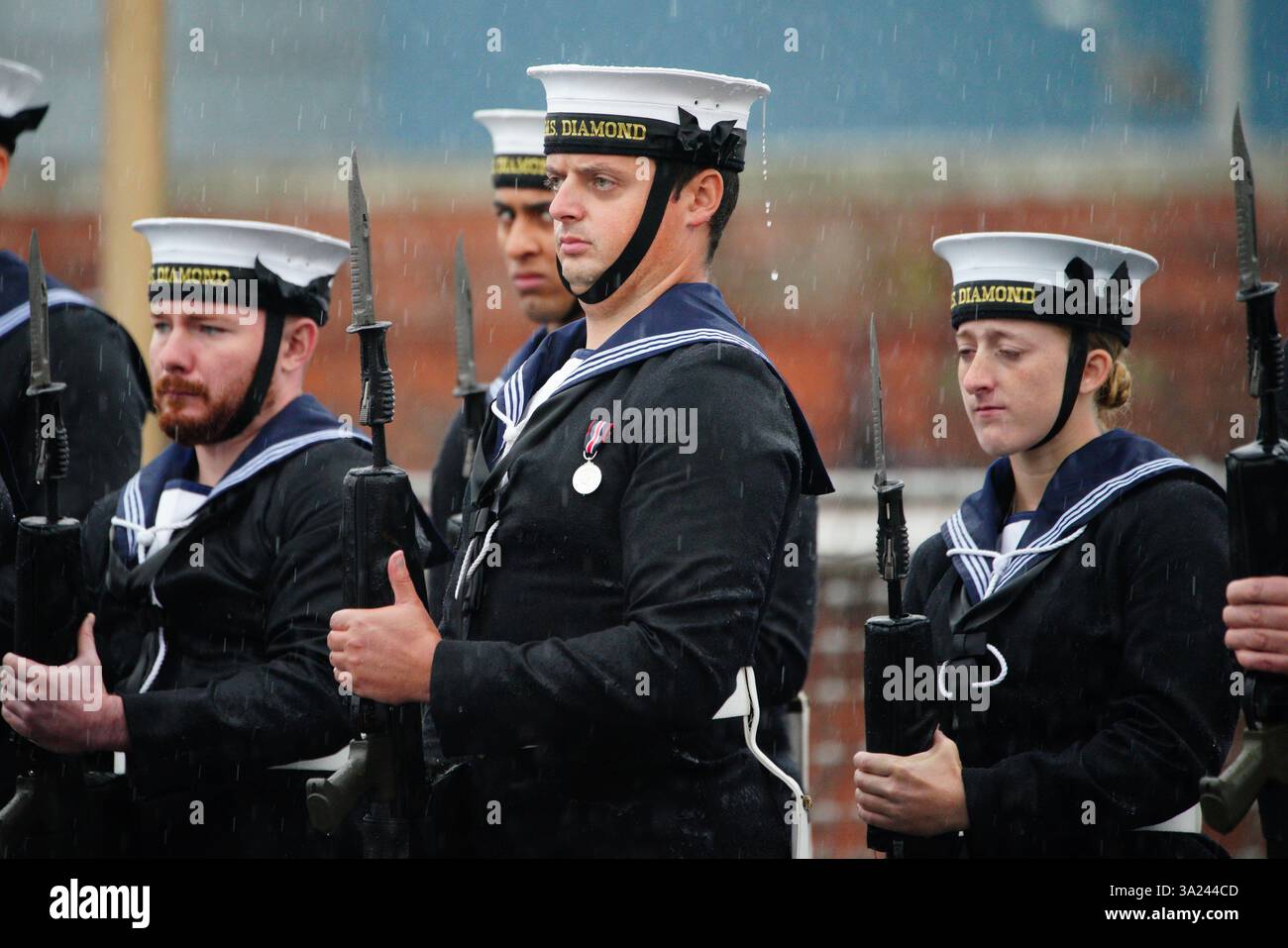 Members of the Royal Navy from HMS Diamond stand on parade in the rain ...