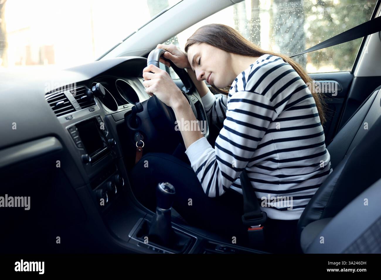 Tired driver sleeping on steering wheel in car Stock Photo - Alamy