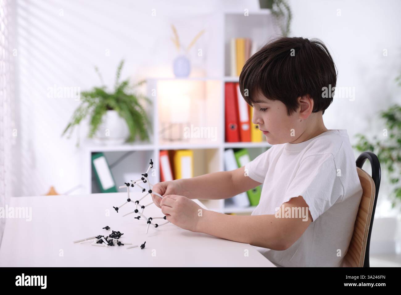 Boy making DNA structure model at desk indoors. Space for text Stock ...