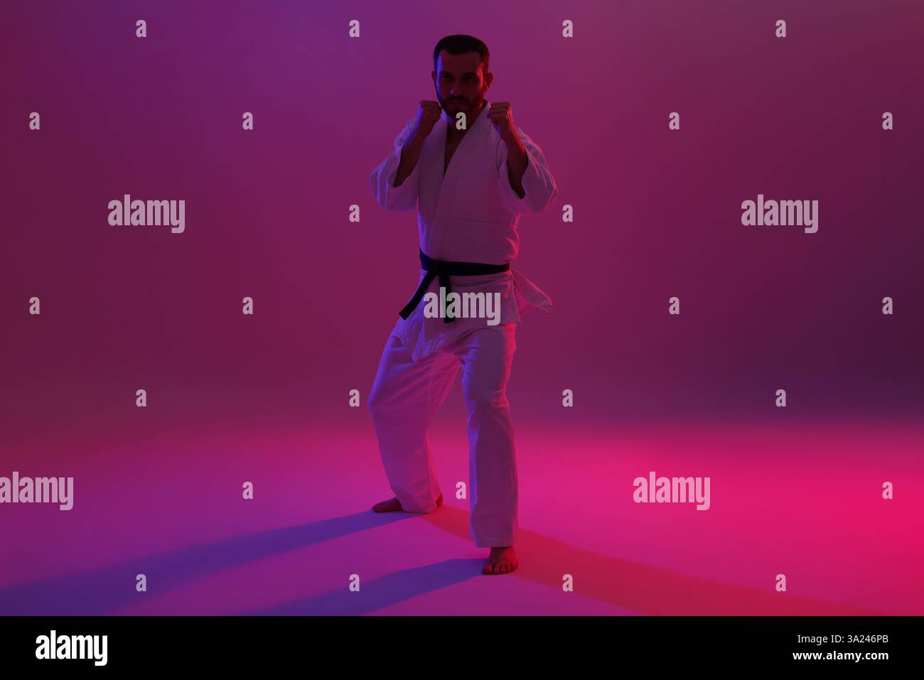 Karate fighter wearing uniform in color lights Stock Photo - Alamy