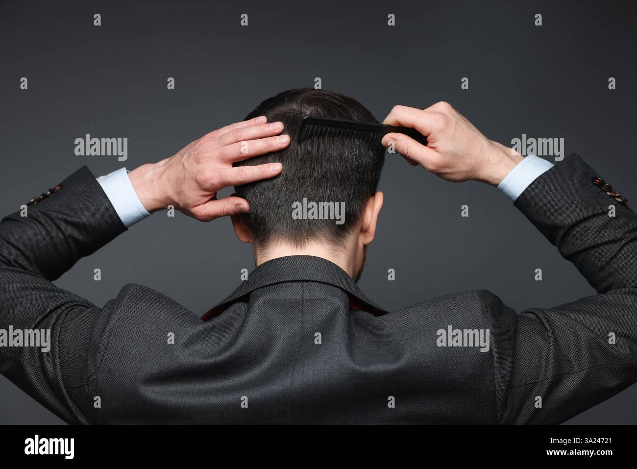 Man combing his hair on dark background, back view Stock Photo - Alamy