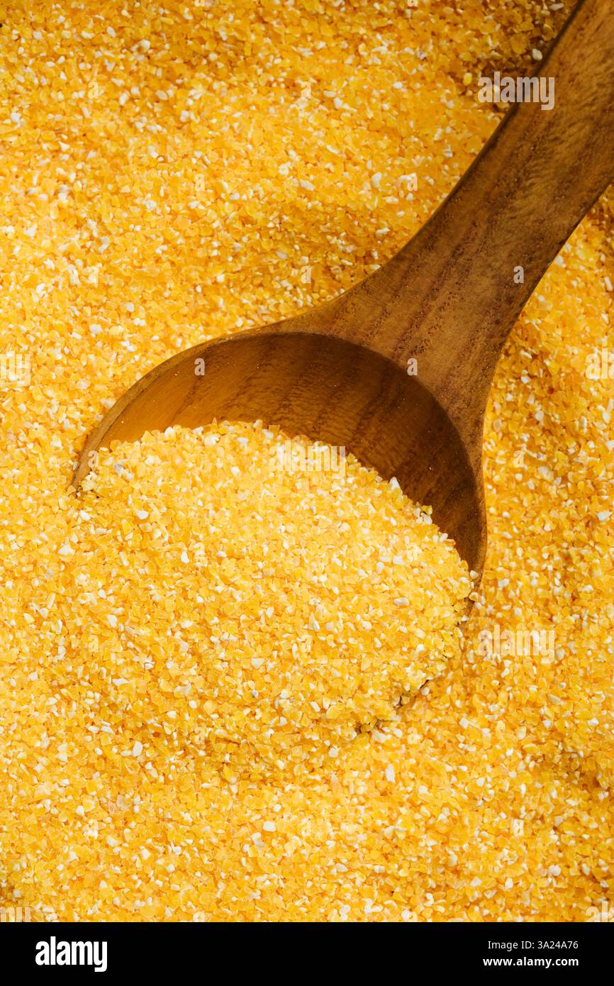 Crushed corn close-up in a wooden spoon Stock Photo - Alamy