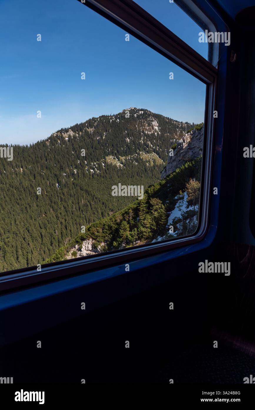 Cog railway window view with mountain peaks in the Bavarian Alps ...