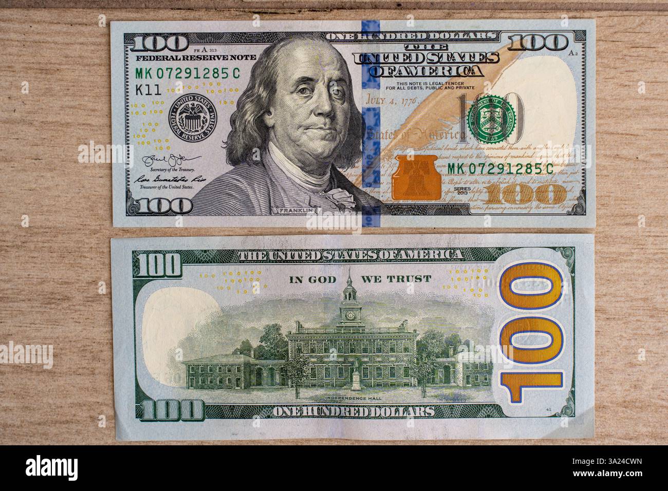 Modern 100 US dollar bill front and back sides on wooden surface ...