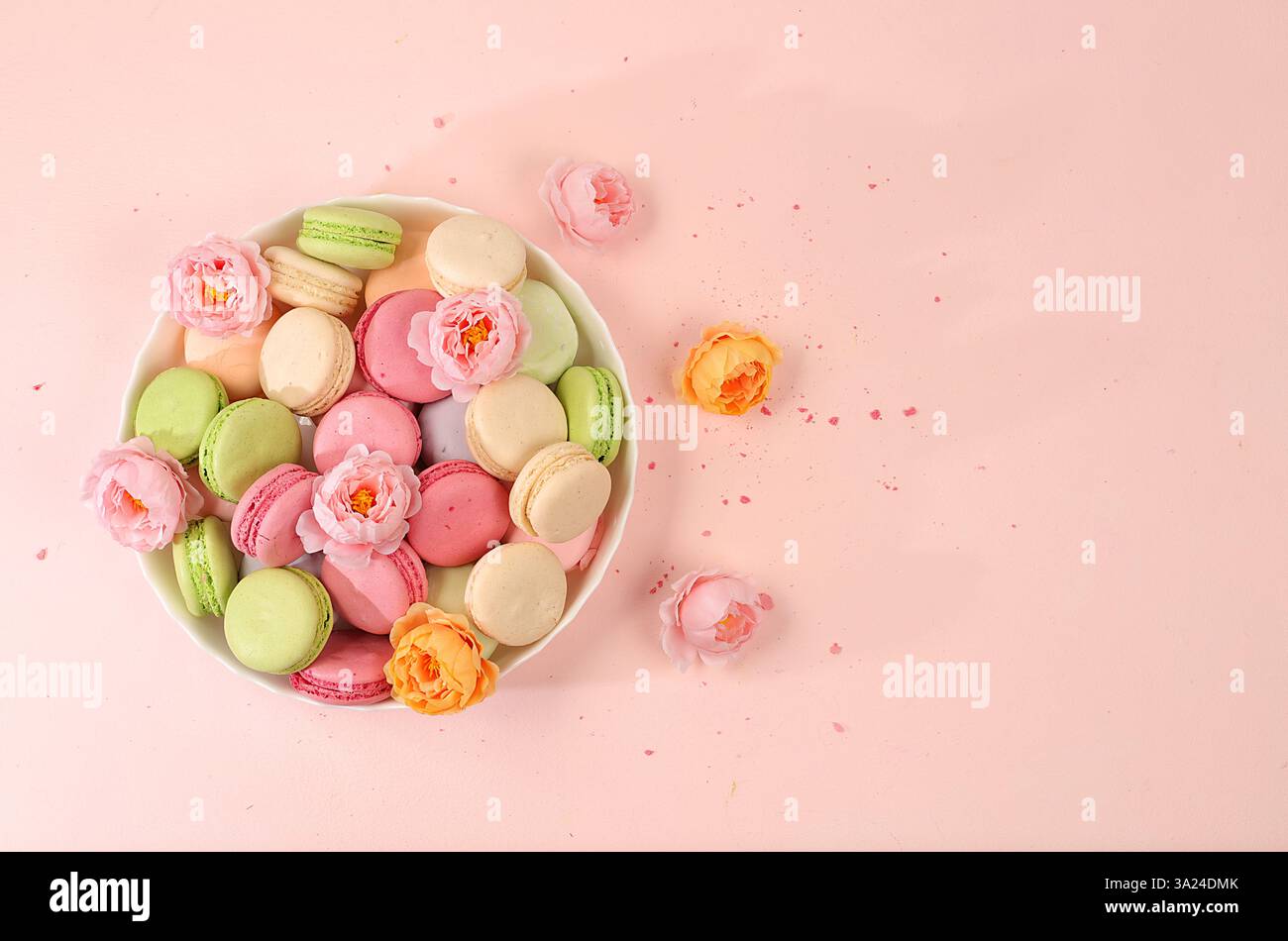 Fresh colorful macaroons in a gift box with flowers, top view. Modern ...