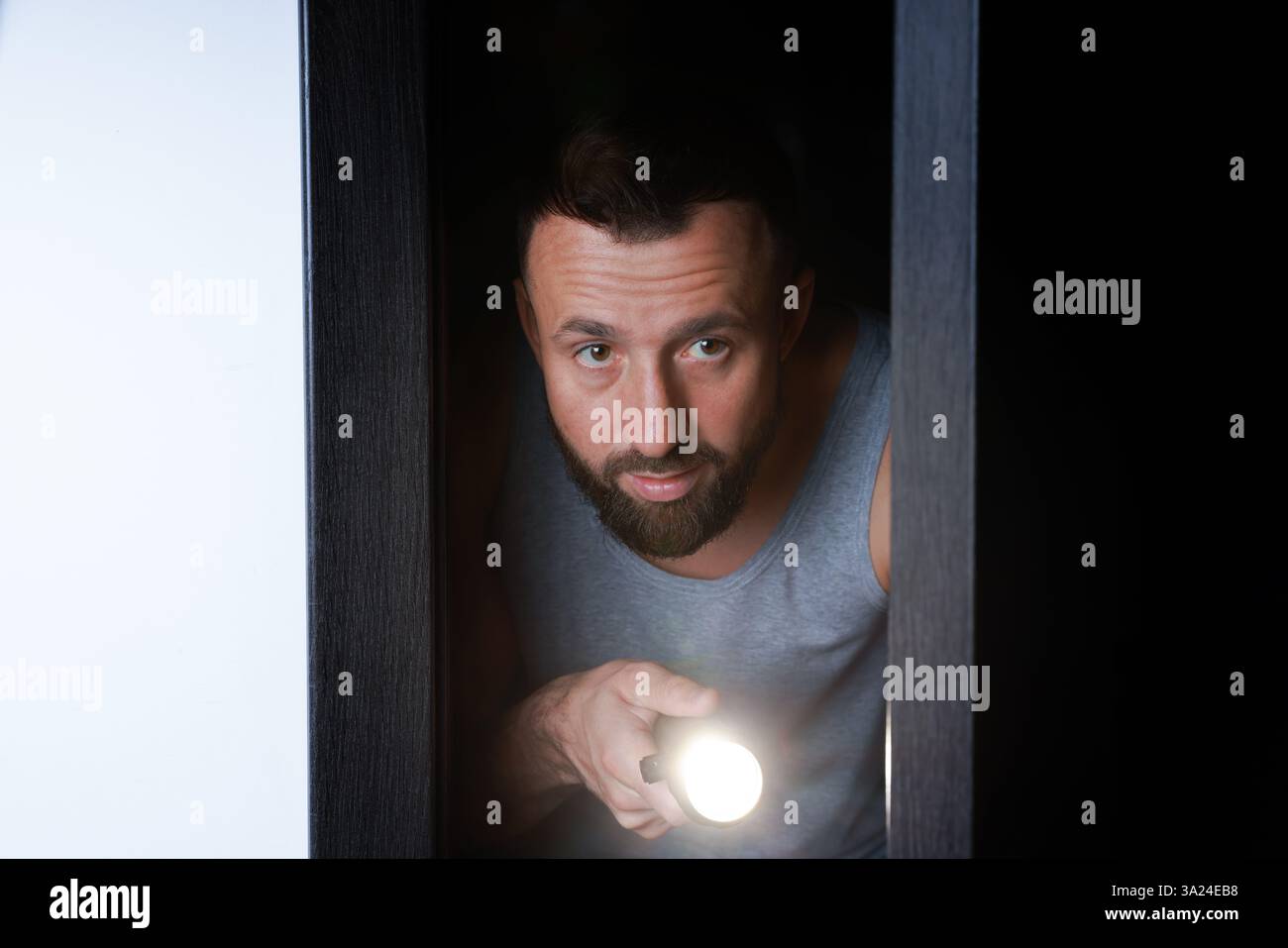 Fear of darkness. Scared man with flashlight in room at night Stock ...