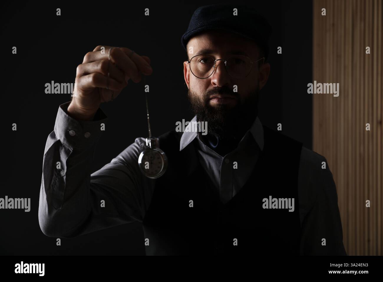 Hypnosis session. Man swinging vintage pocket watch indoors Stock Photo ...