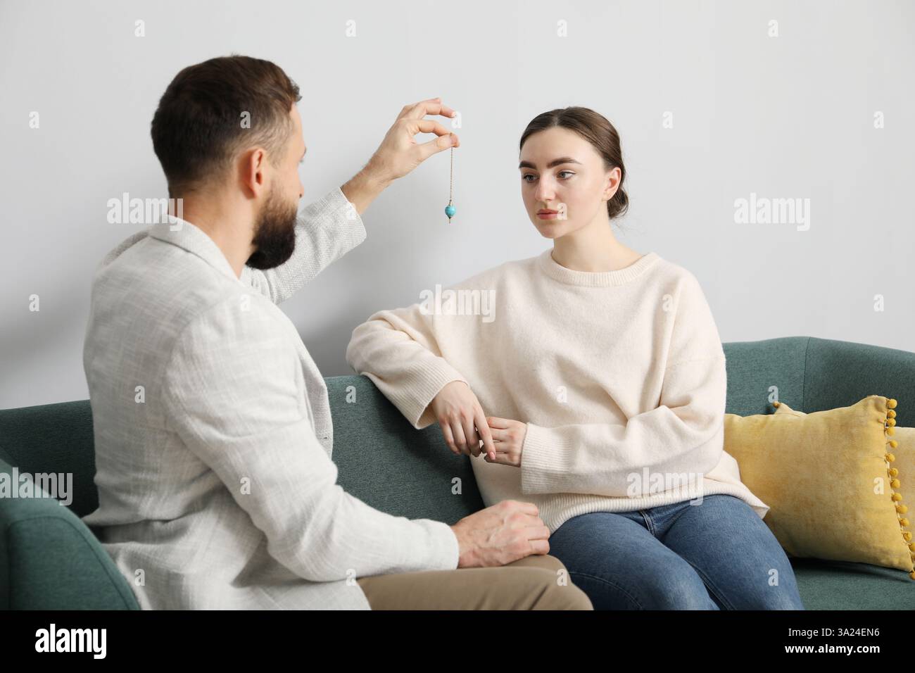 Psychologist using pendulum while working with patient during hypnosis ...